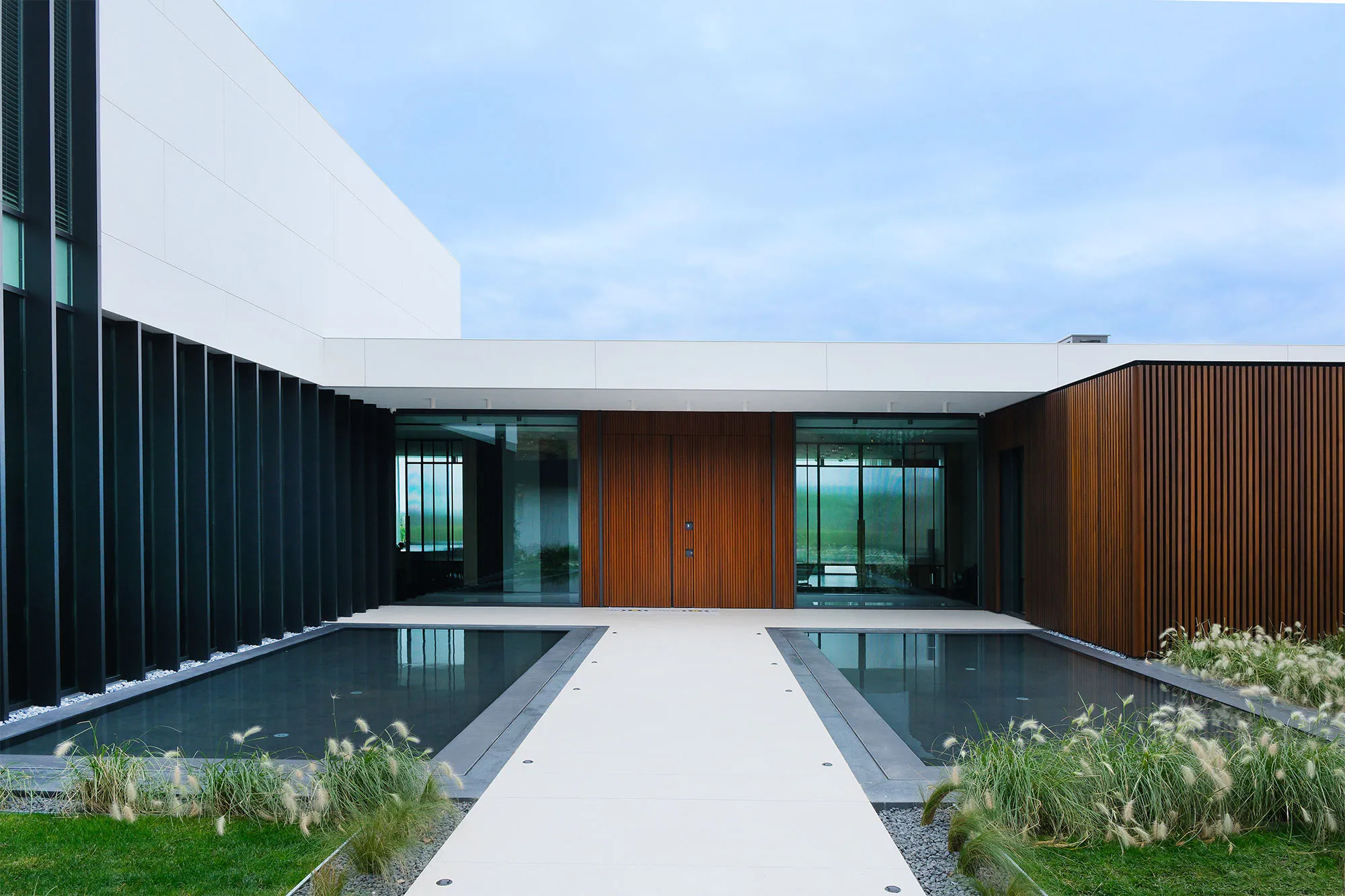 A luxury villa with pools and finished in white, black, and Cosentino ...