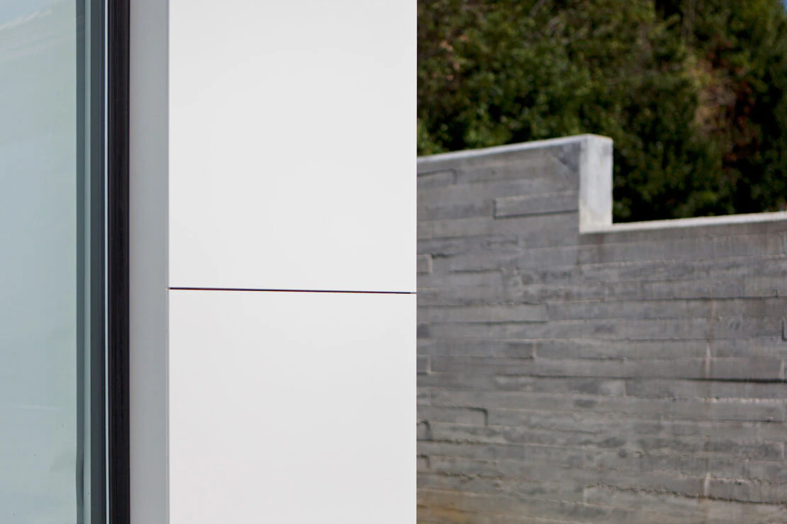 The white Dekton façade of this single-family house in Sanxenxo catches ...