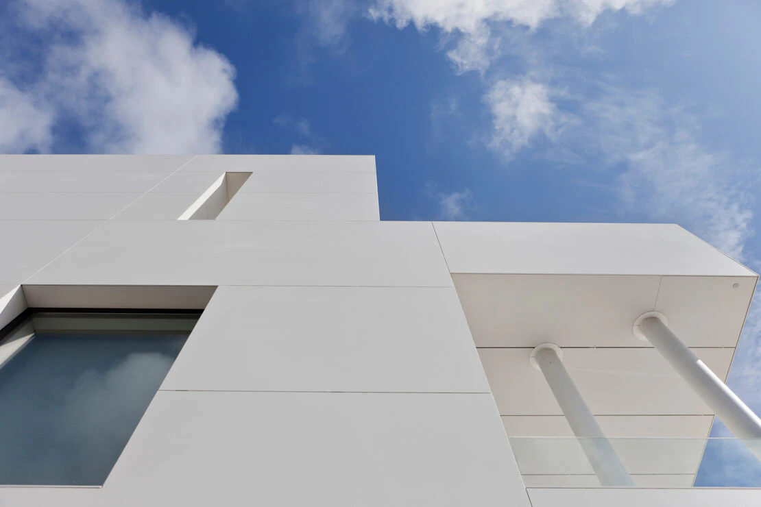 The white Dekton façade of this single-family house in Sanxenxo catches ...