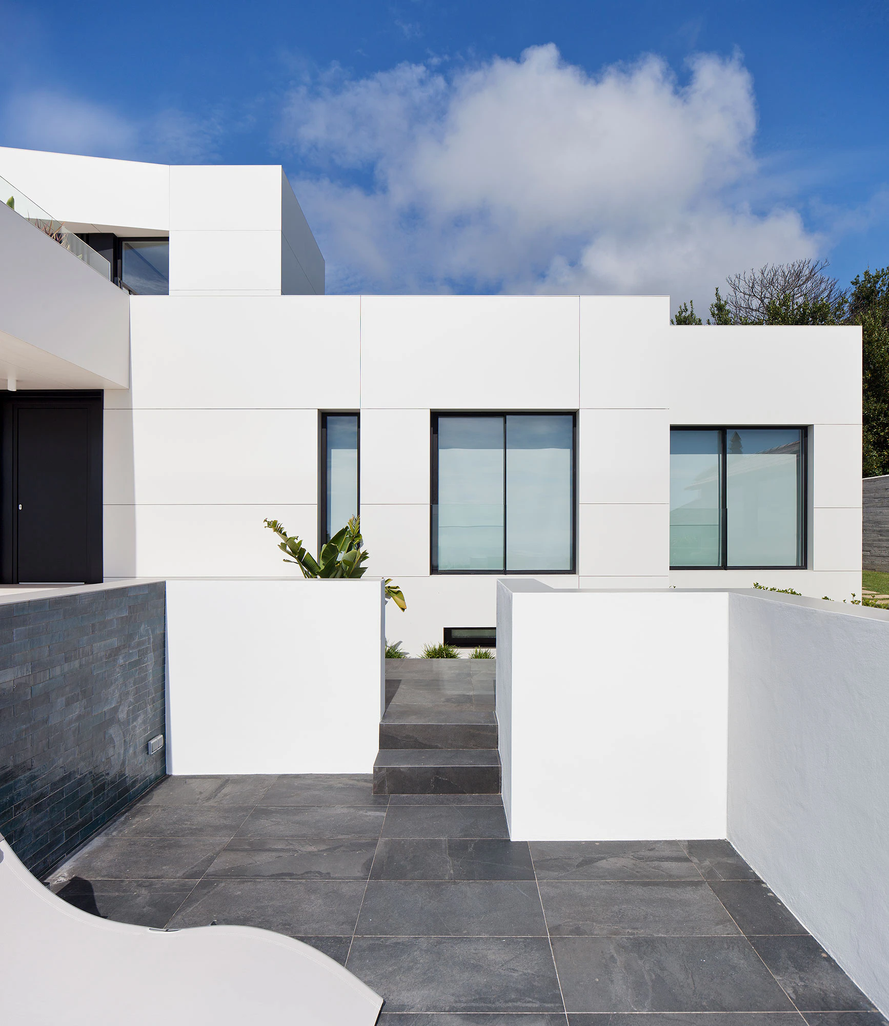 The white Dekton façade of this single-family house in Sanxenxo catches ...