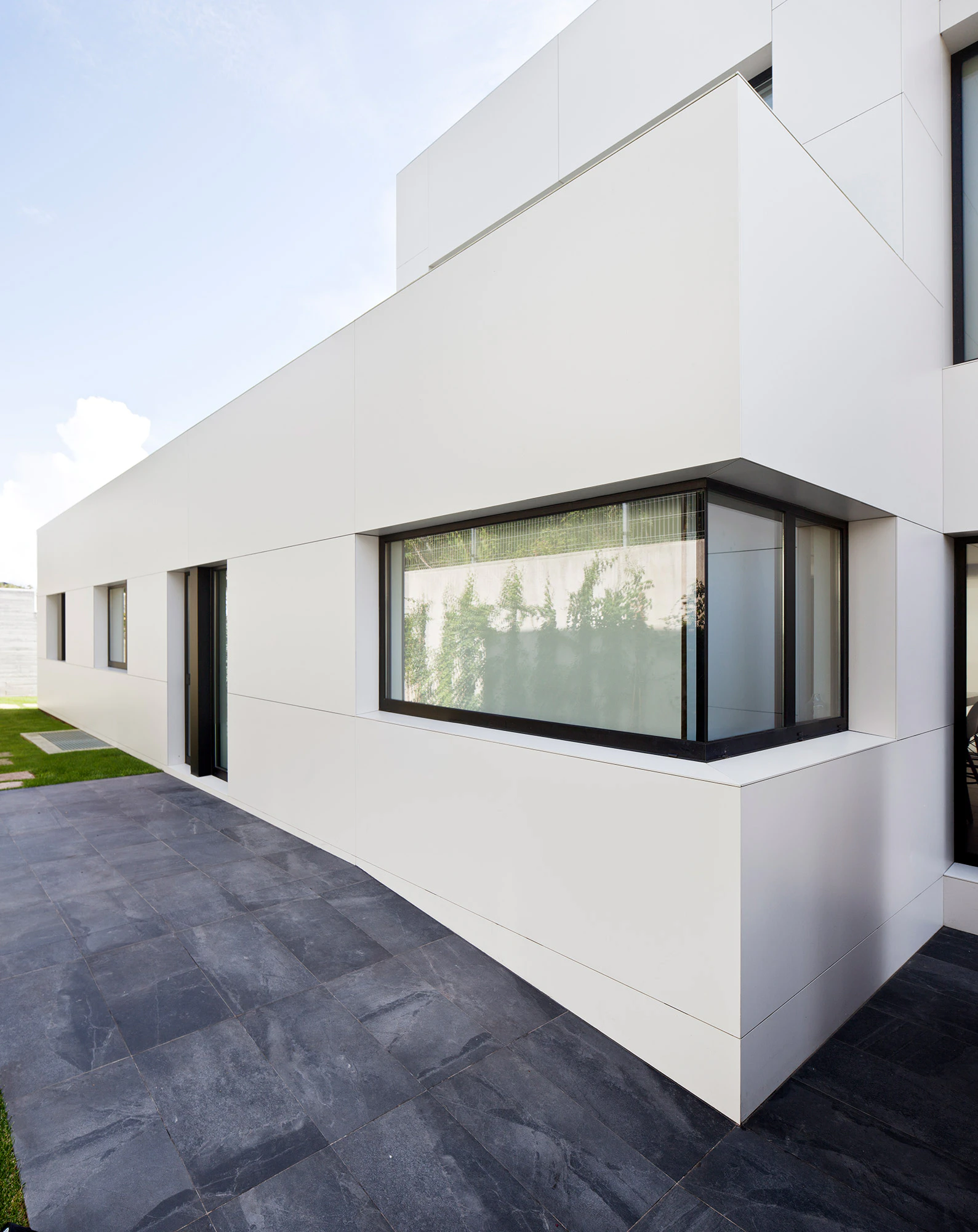 The white Dekton façade of this single-family house in Sanxenxo catches ...