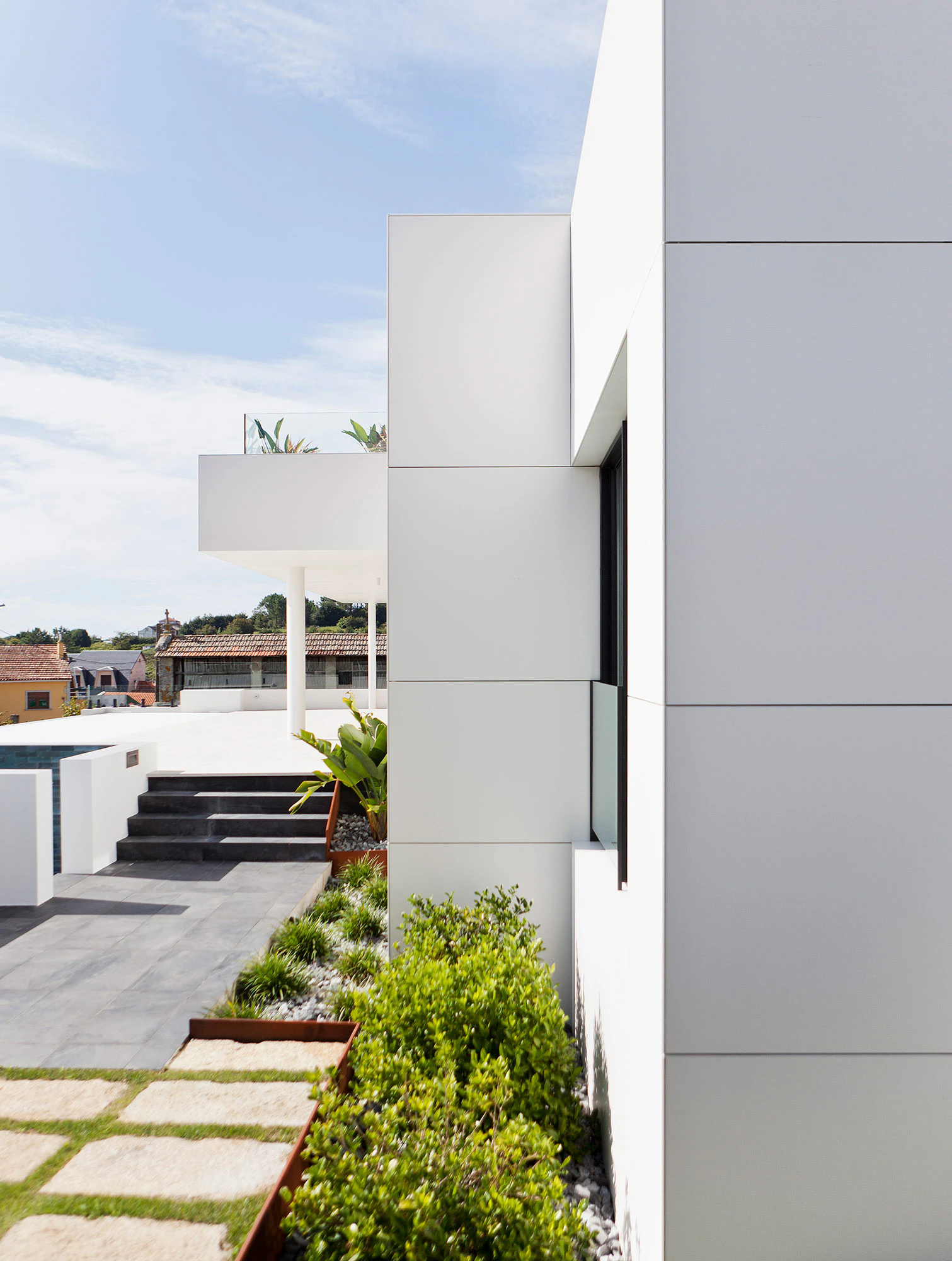 The white Dekton façade of this single-family house in Sanxenxo catches ...
