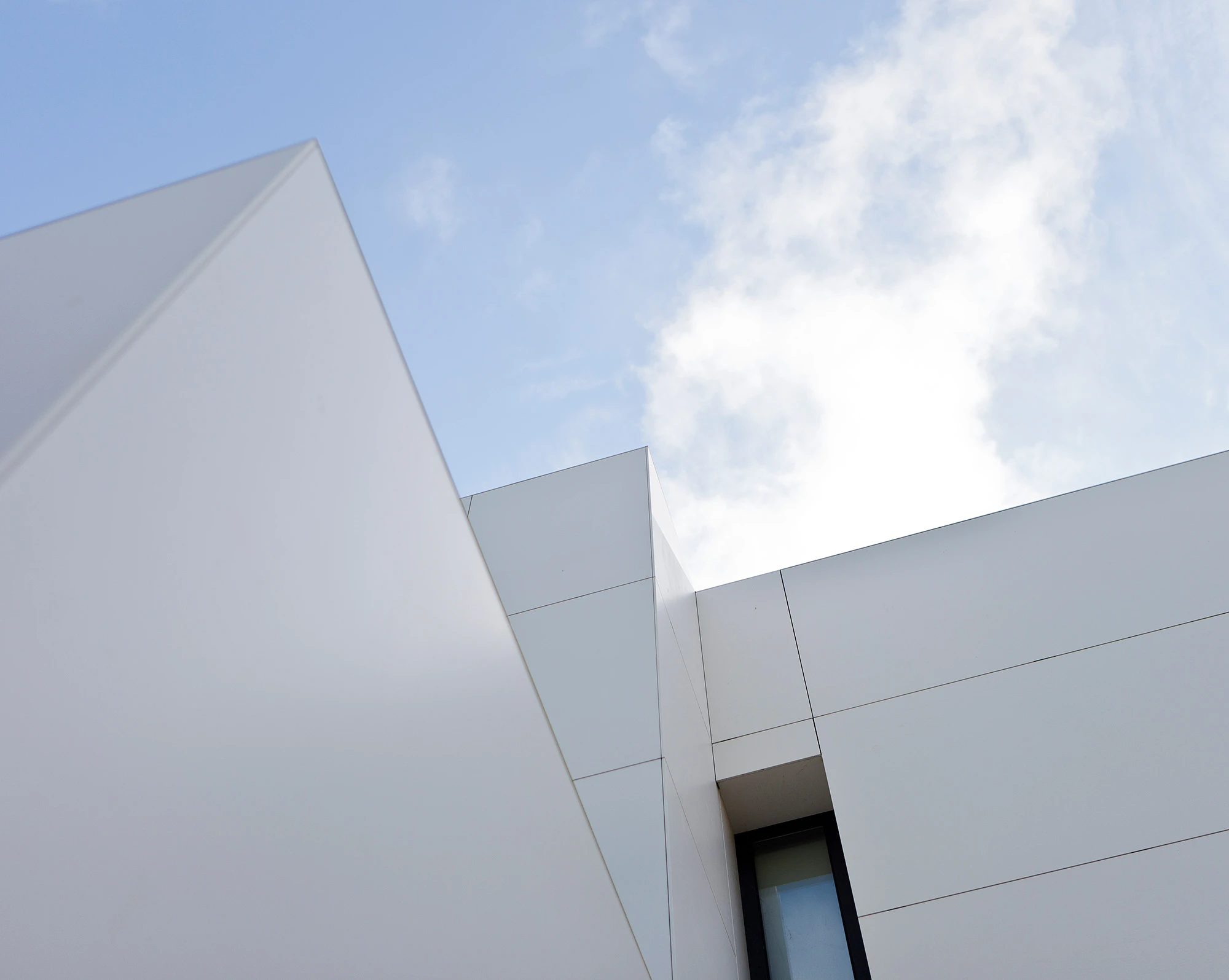 The white Dekton façade of this single-family house in Sanxenxo catches ...
